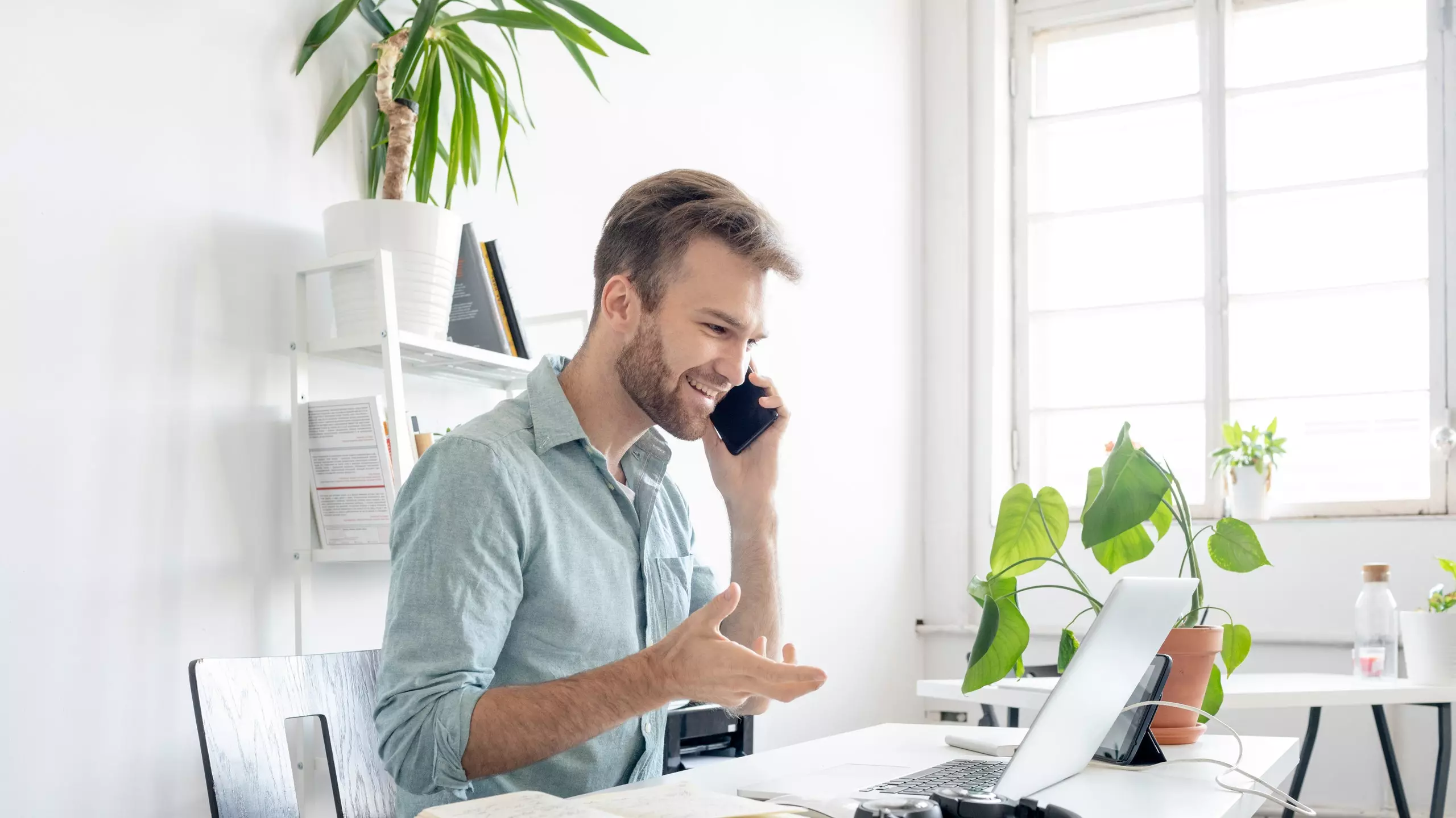 Naeratav mees telefonis kontoris laua taga