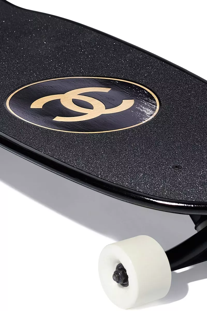 Lacquered wooden skateboard with Chanel logo.