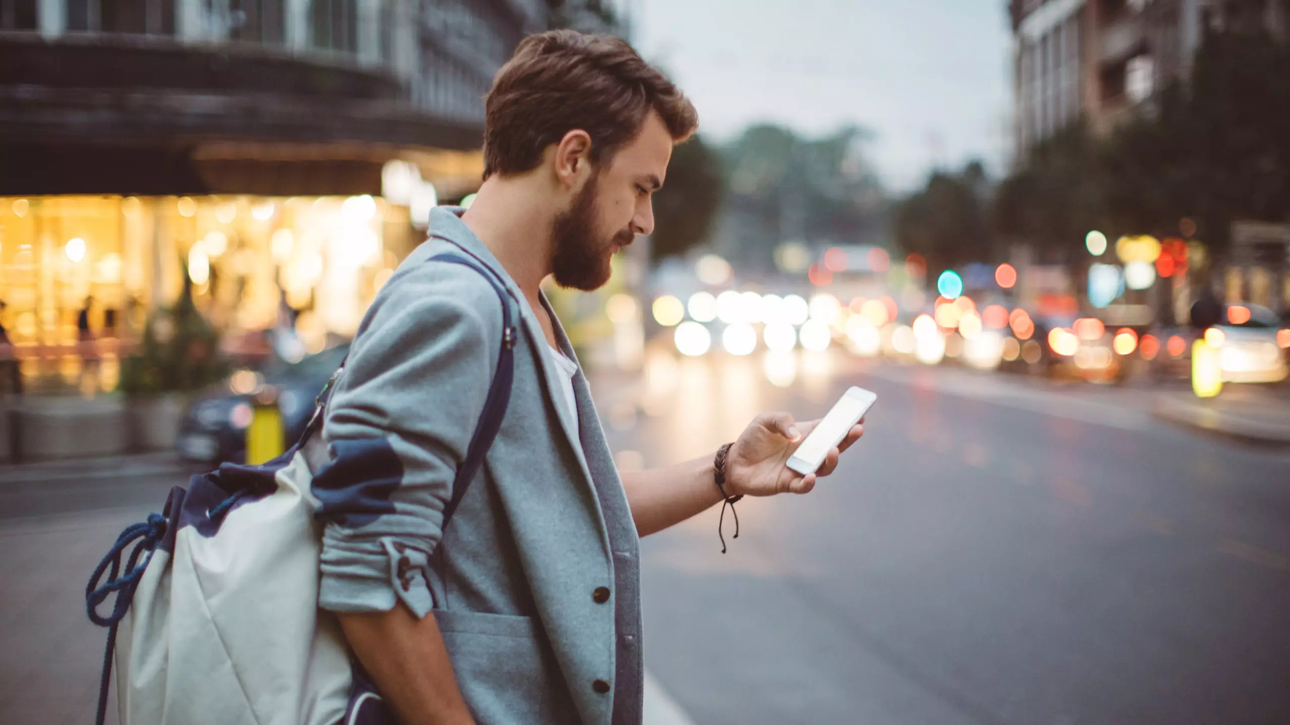 man met mobiel in zijn hand op straat