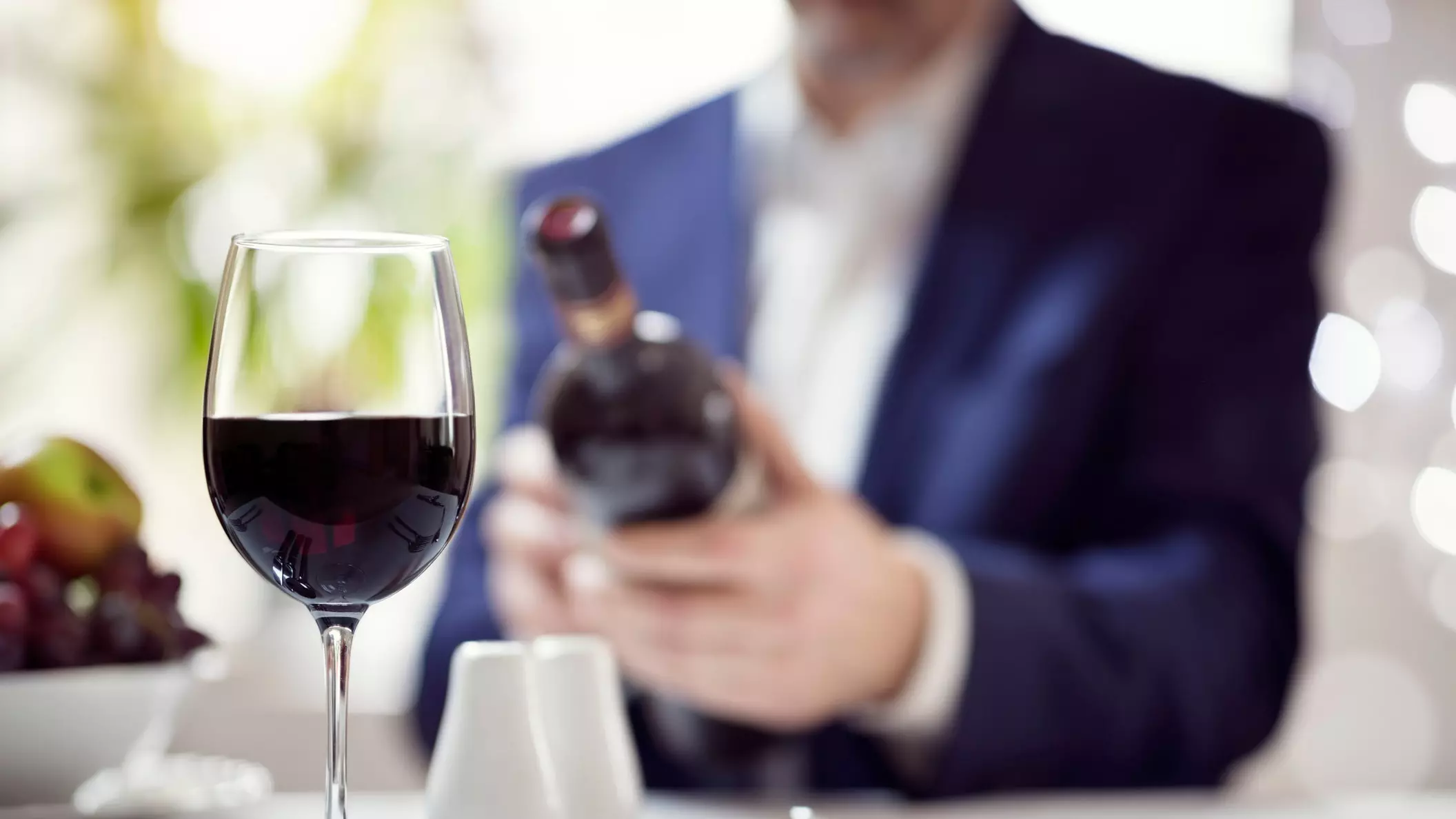 Homme d'affaires lisant l'étiquette de la bouteille de vin rouge dans le concept de restaurant pour un déjeuner ou un dîner d'affaires