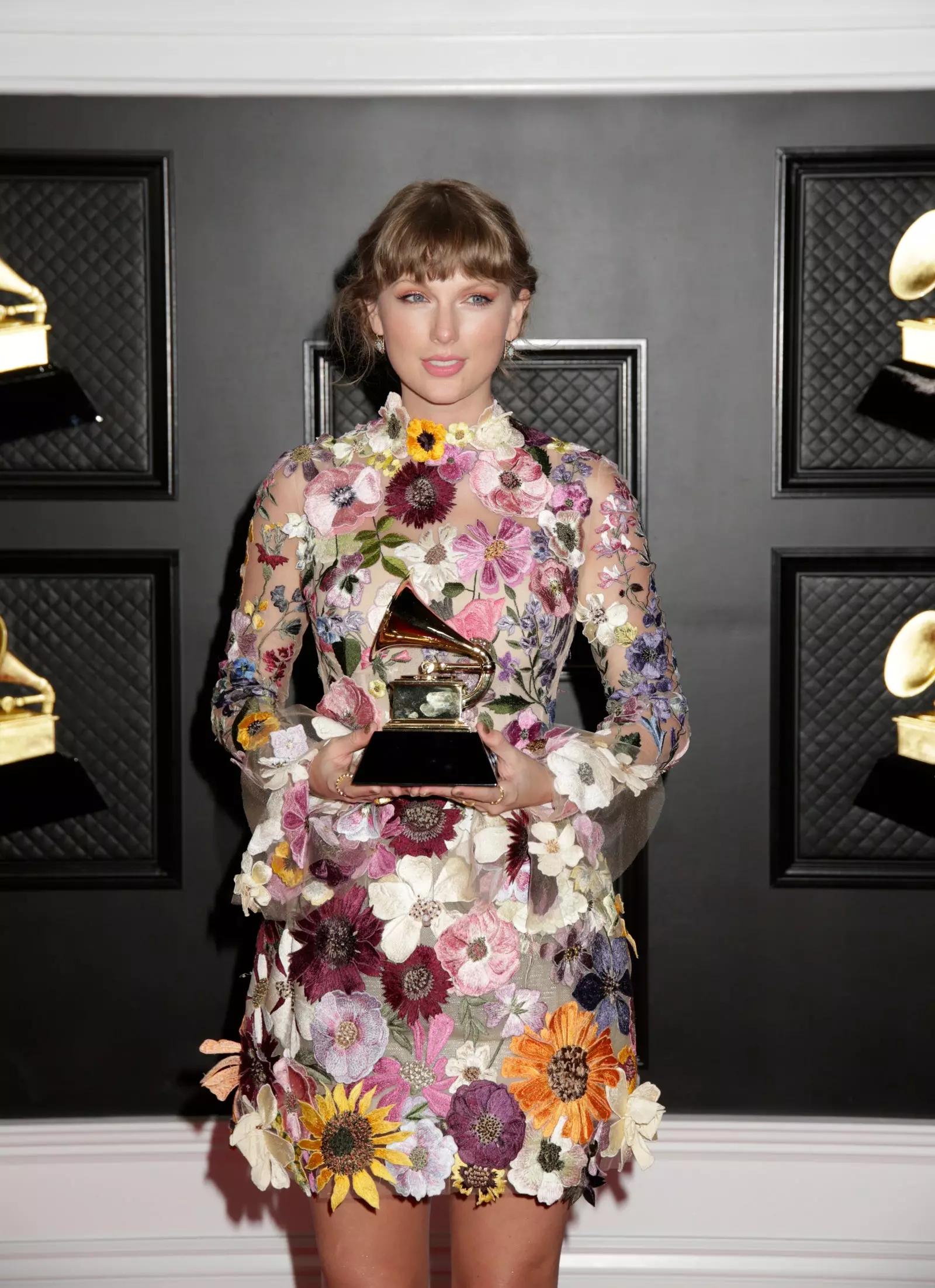 Taylor Swift nhận giải Grammy cho Album xuất sắc nhất của năm với thể loại Văn học dân gian khi mặc một chiếc váy của Oscar de la Renta.