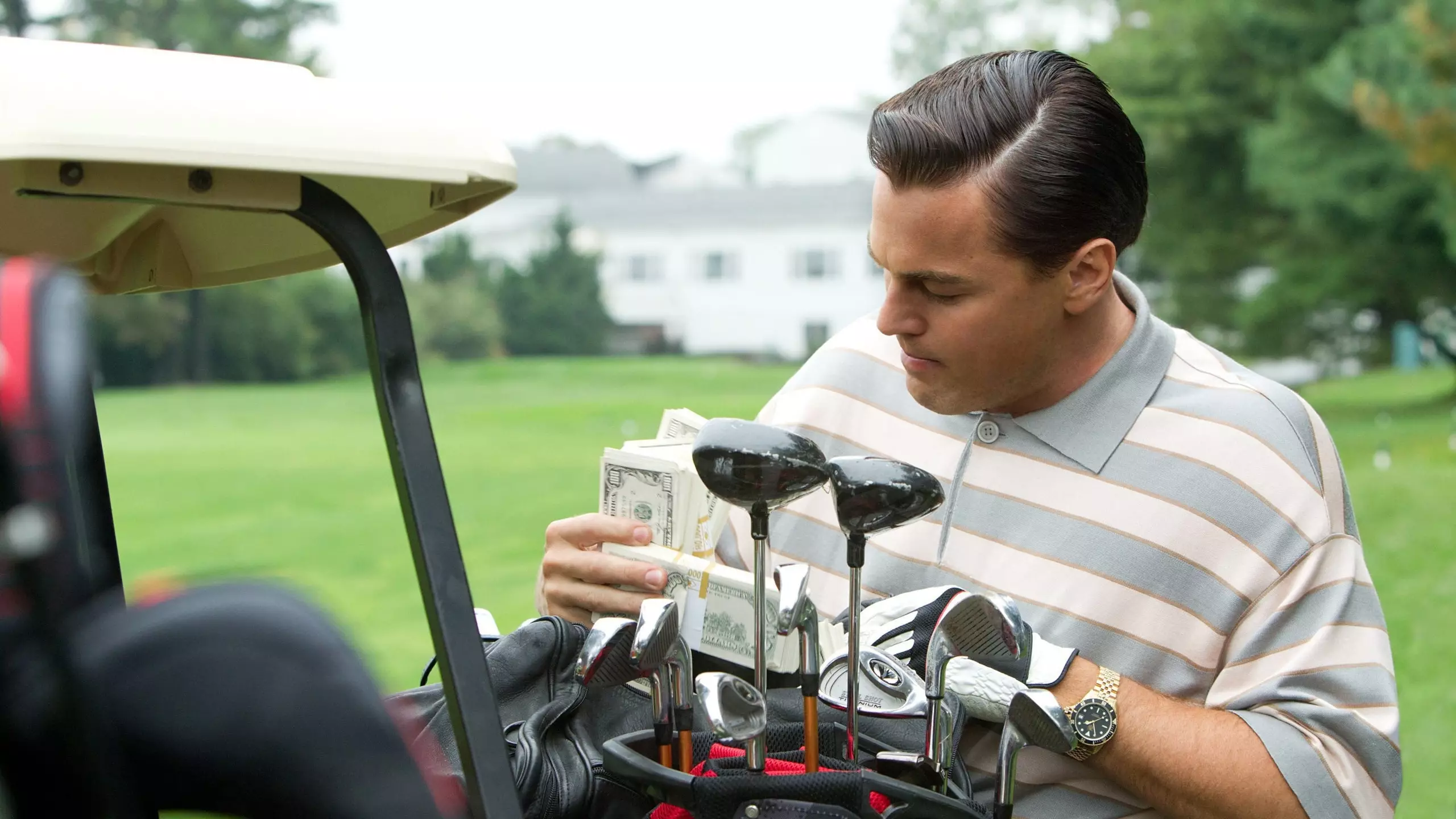 čovjek s novcem u kolicima za golf