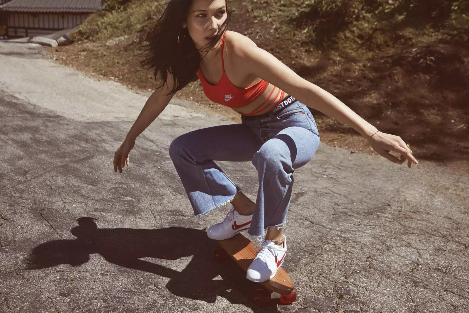 Bella Hadid ag athchruthú radharc Farah Fawcett i Charlie's Angels do chomóradh 45 bliain an Nike Cortez.