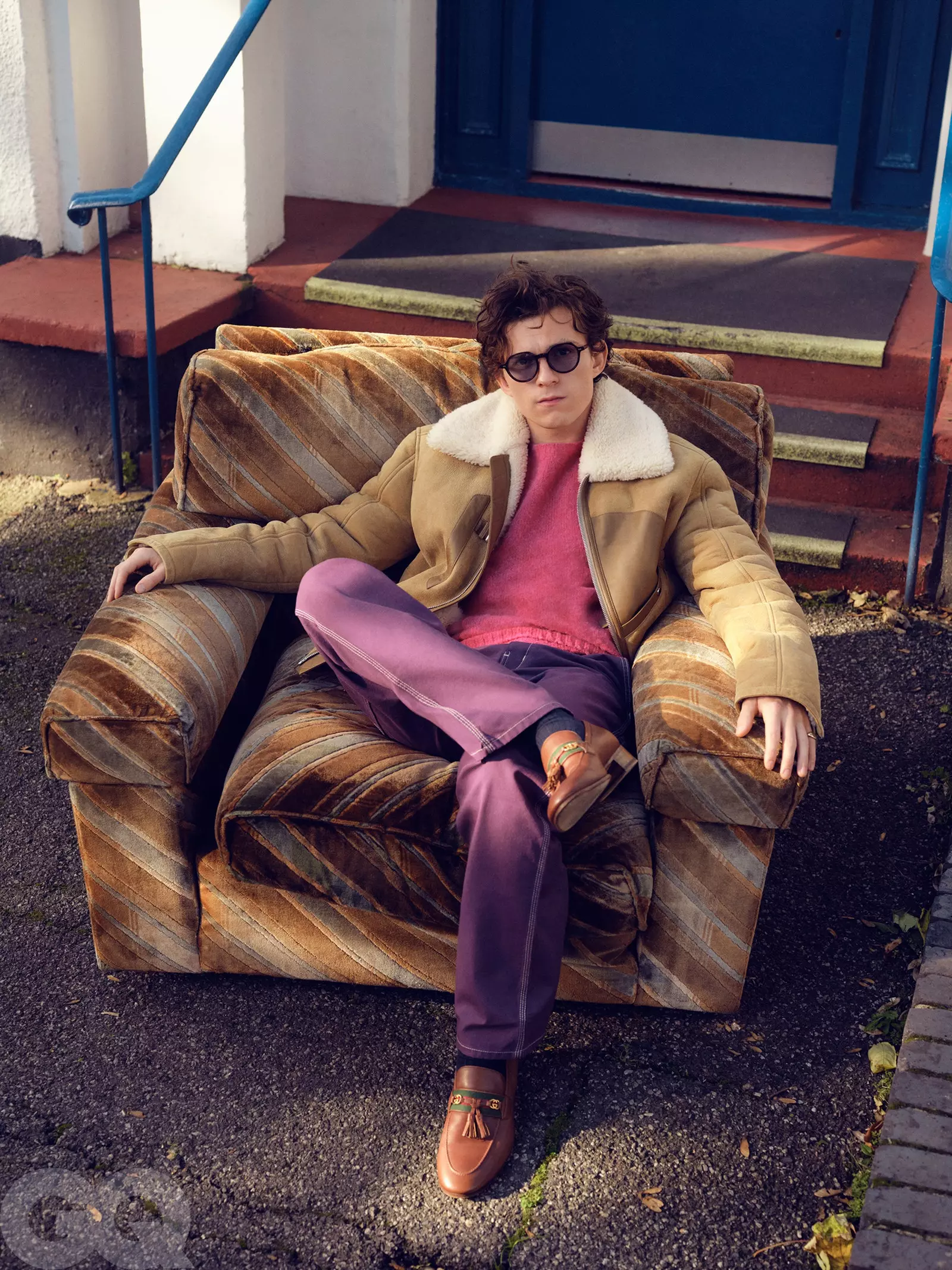 L'image peut contenir des meubles, un canapé, une chaise, un fauteuil, des lunettes de soleil, des accessoires, une personne humaine et Tom Holland.